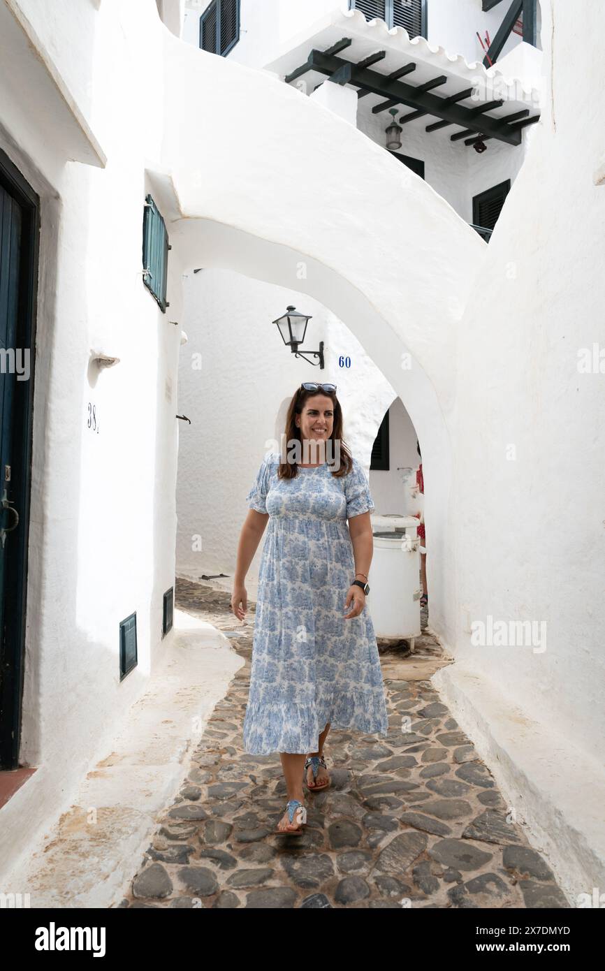A 35 year old woman walks through the charming white streets of ...