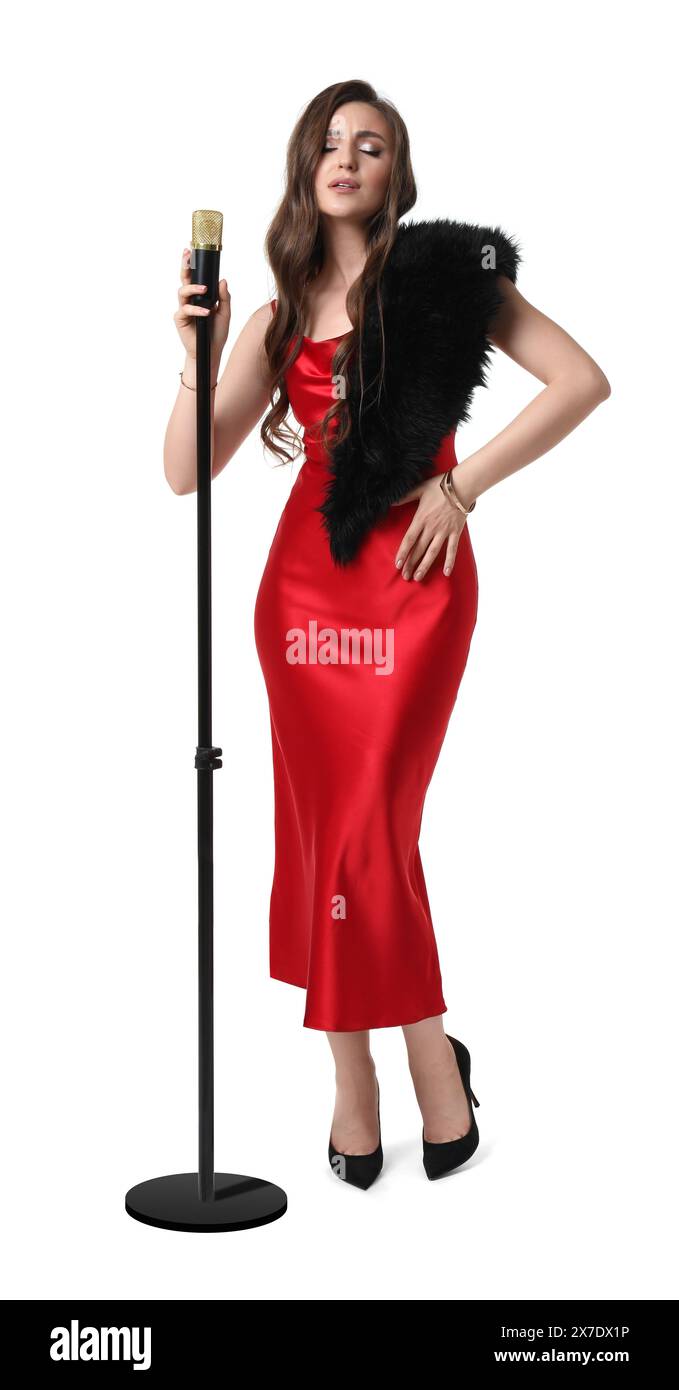 Beautiful young woman in stylish red dress with microphone singing on ...