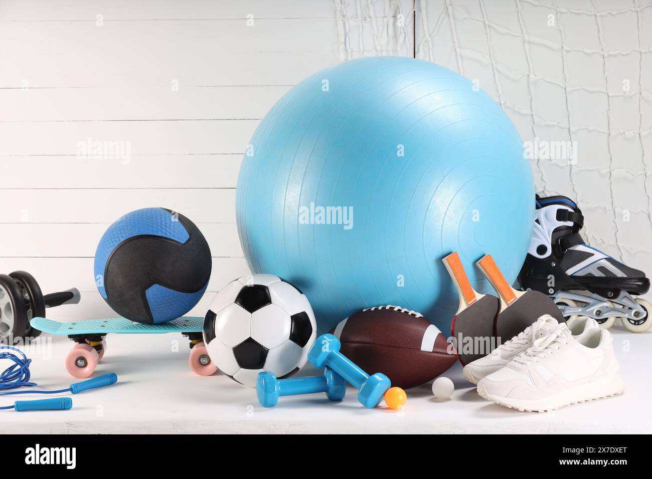 Many different sports equipment on white table Stock Photo - Alamy