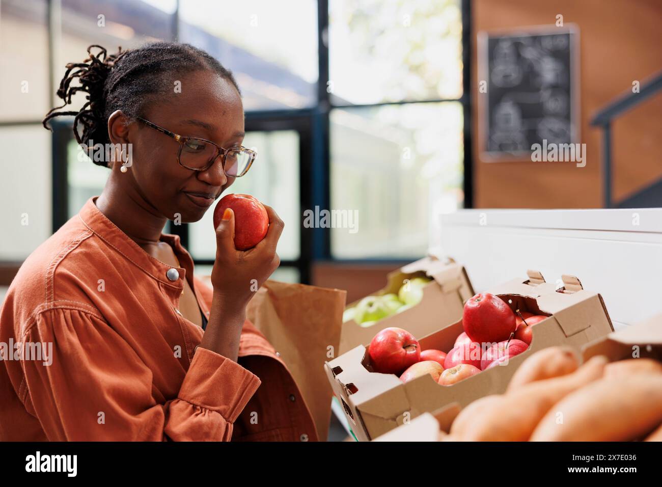African american customer grasping and smelling fresh red apple ...