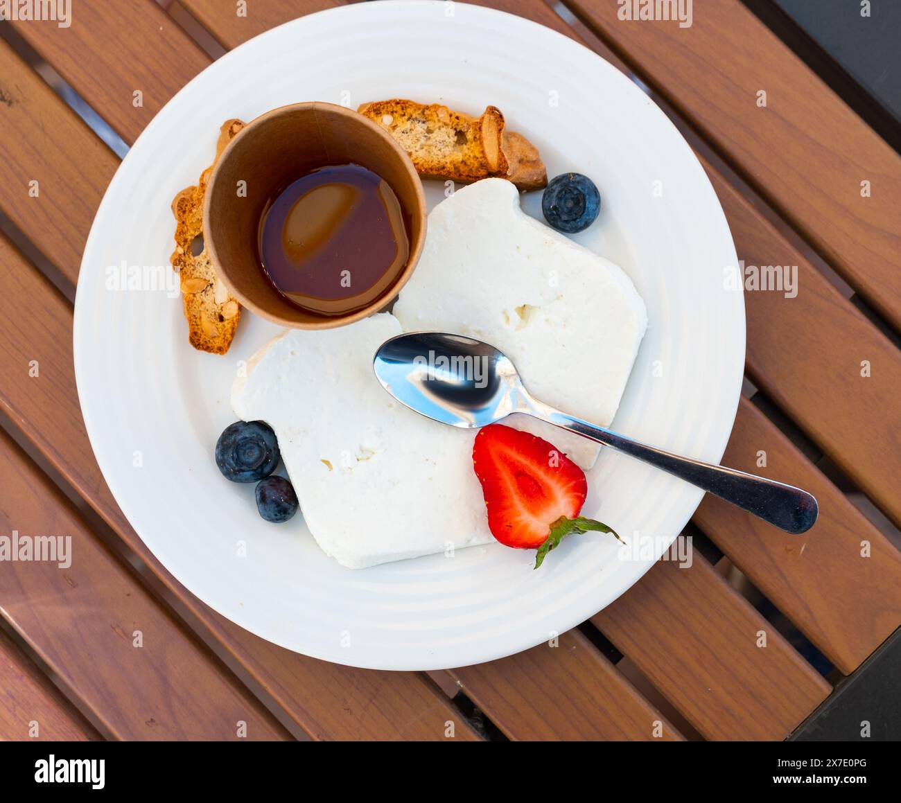 Mato cheese served with honey and berries Stock Photo - Alamy