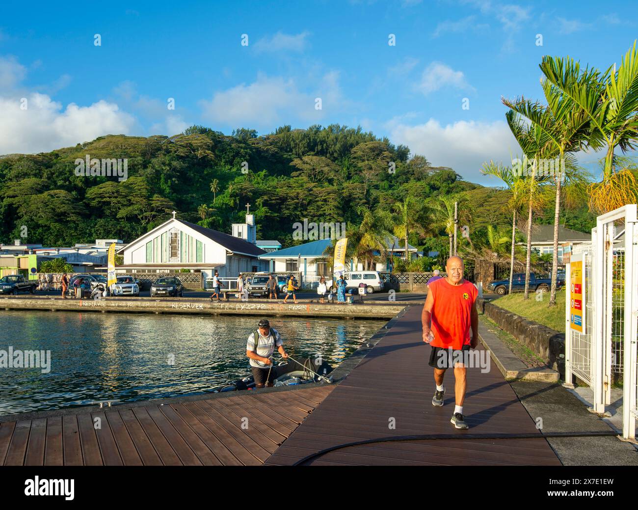 Man with a red shirt walking in the port of Uturoa, Raiatea Island main ...