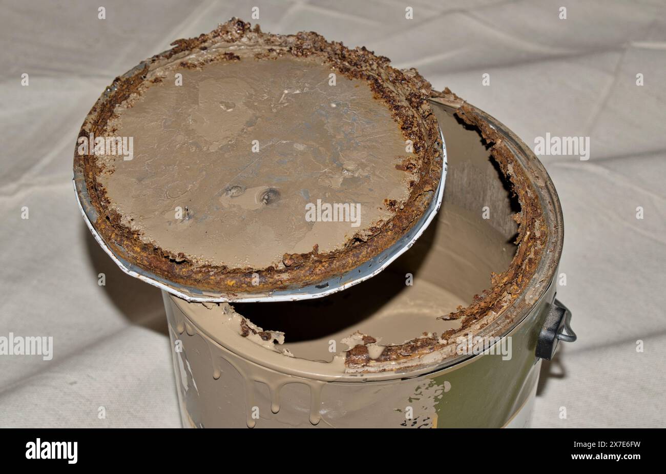 Rusted old metal paint tin with open lid on drop cloth brown expired ...