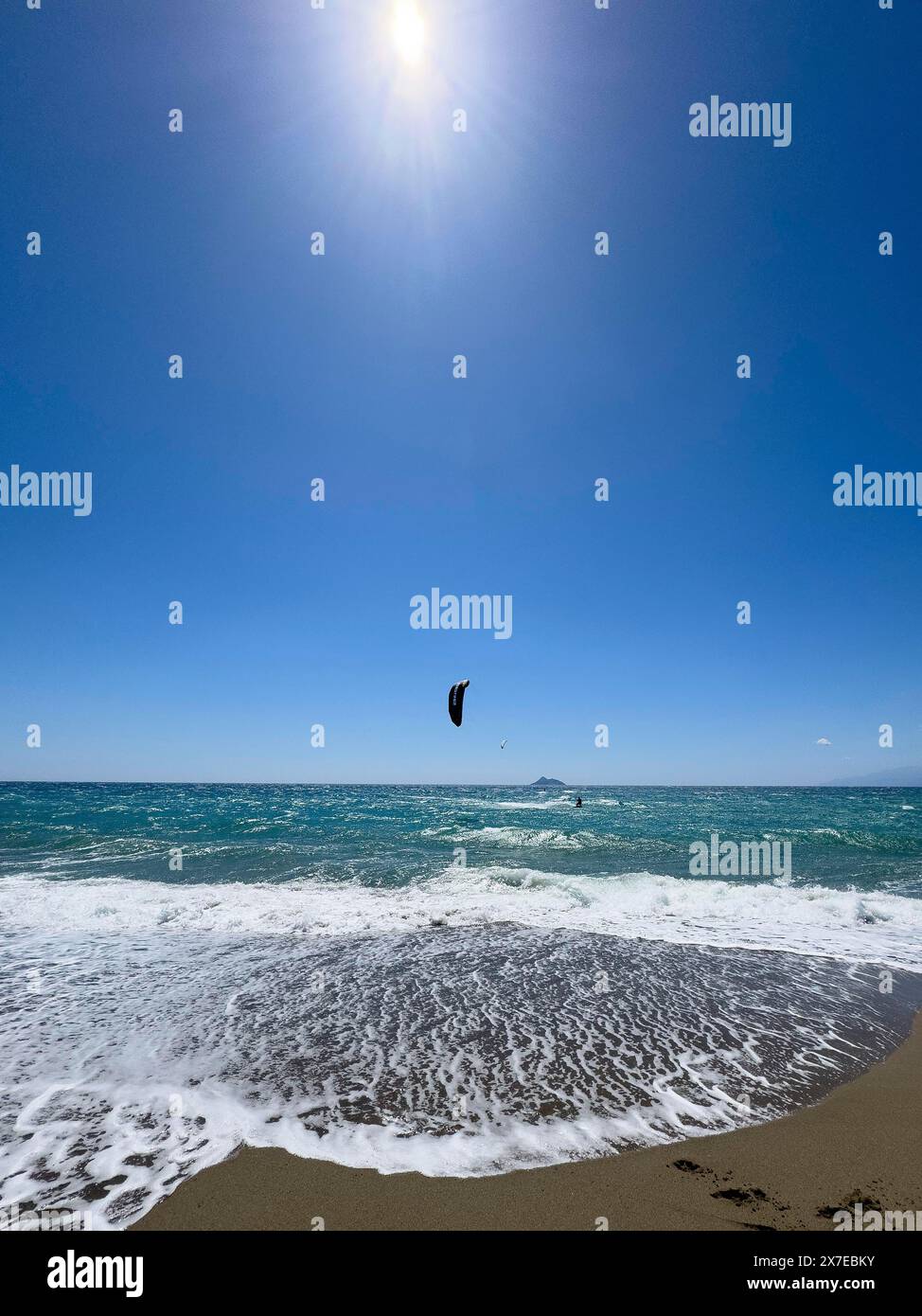 Kitesurfer kite surfer surfing in strong wind and waves rough sea ...