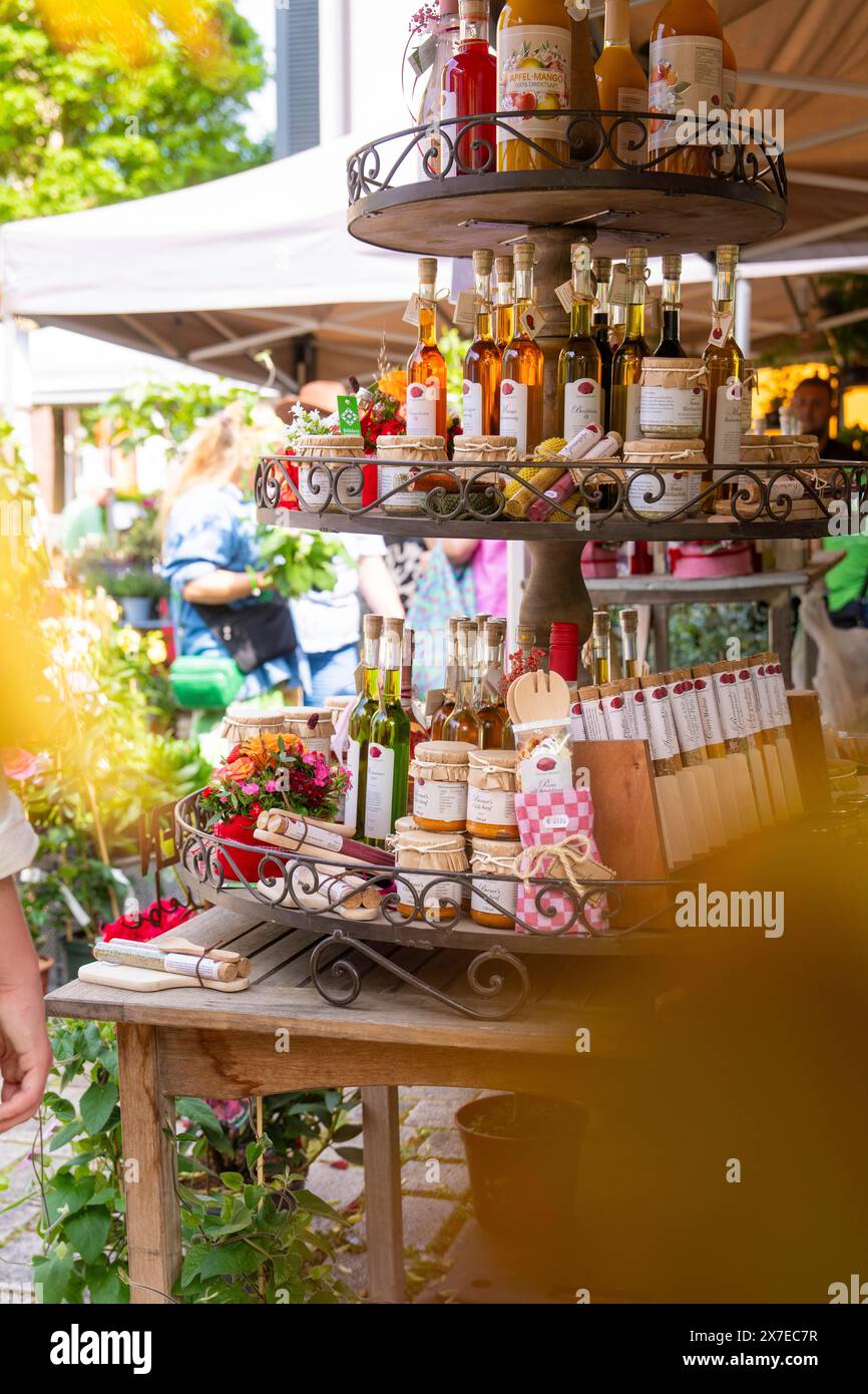 A stall at a market displays various bottles and food products on ...