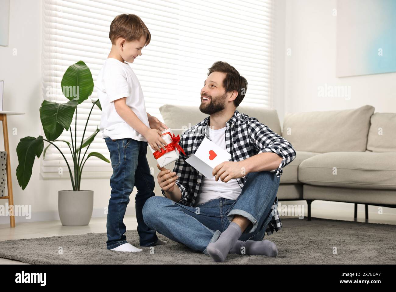 Happy Father's Day. Son giving gift box to his father with greeting ...