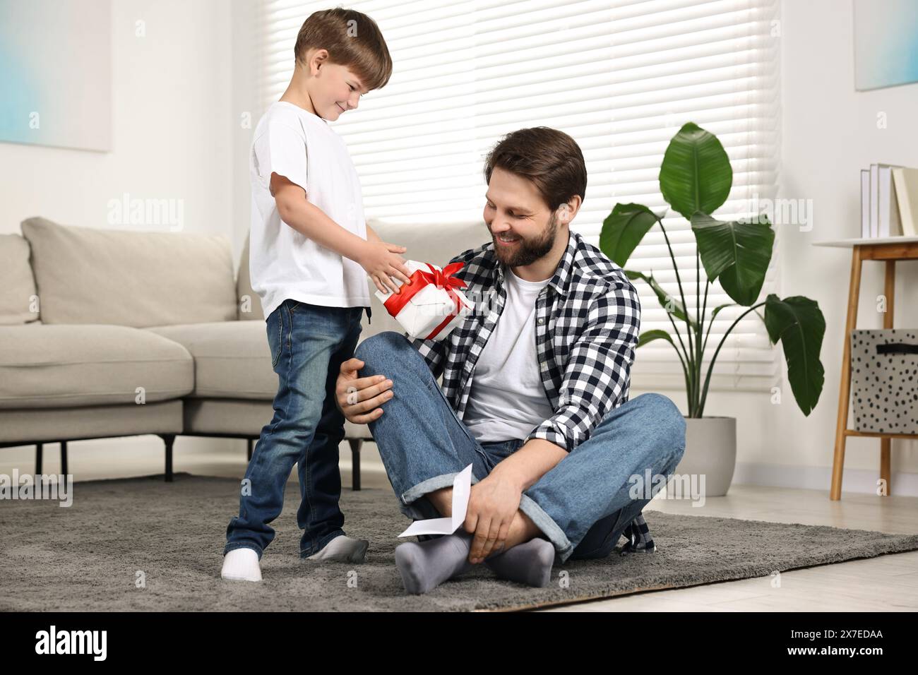 Happy Father's Day. Son giving gift box to his father with greeting ...