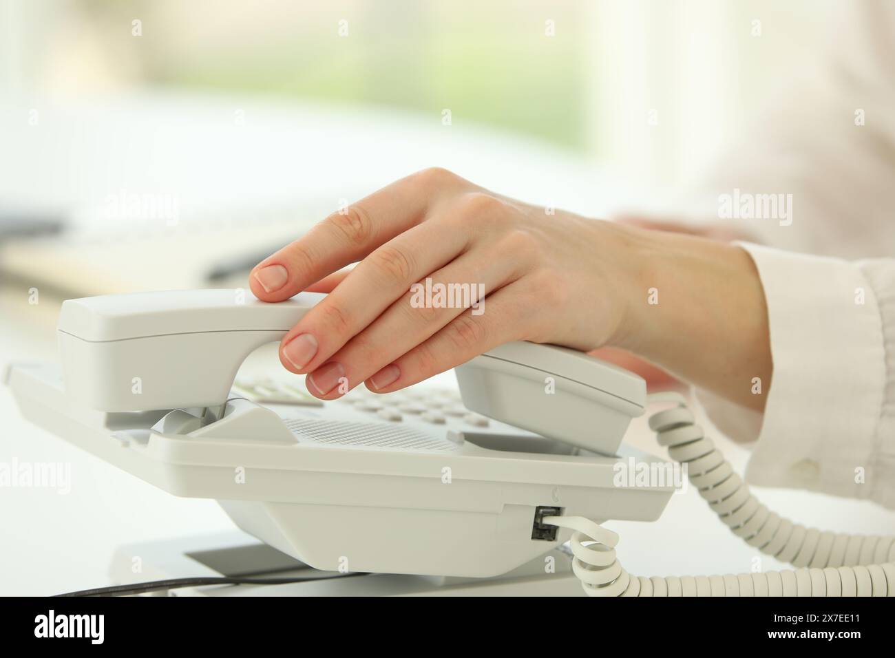 Assistant taking telephone handset on blurred background, closeup Stock ...