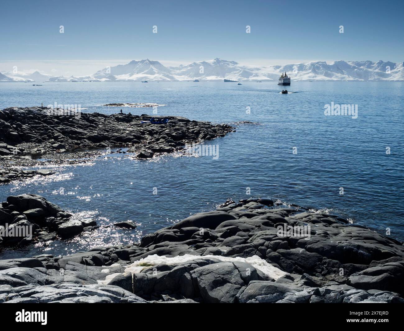 Tourist cruise ship disembarking passengers on the rocky shore at ...