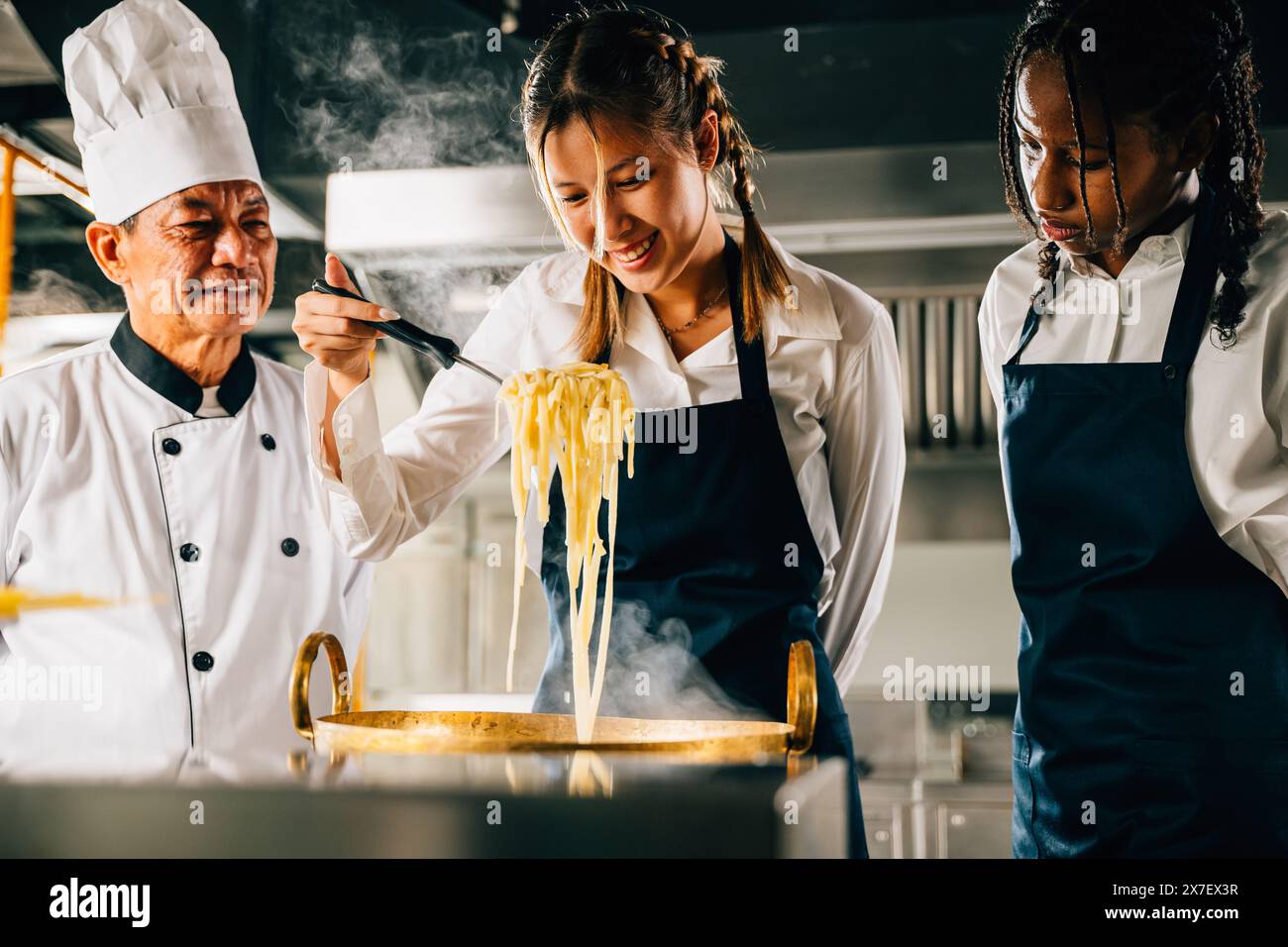 In kitchen chef teaches noodle cooking to students. Schoolgirls in ...