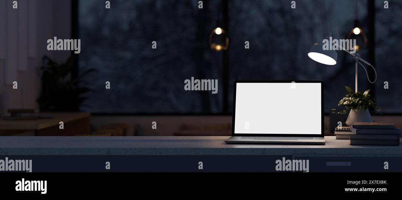 A modern dark office at night features a white-screen laptop computer ...