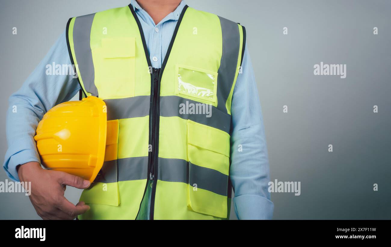 Civil engineer architect standing holding a safety helmet on grey ...