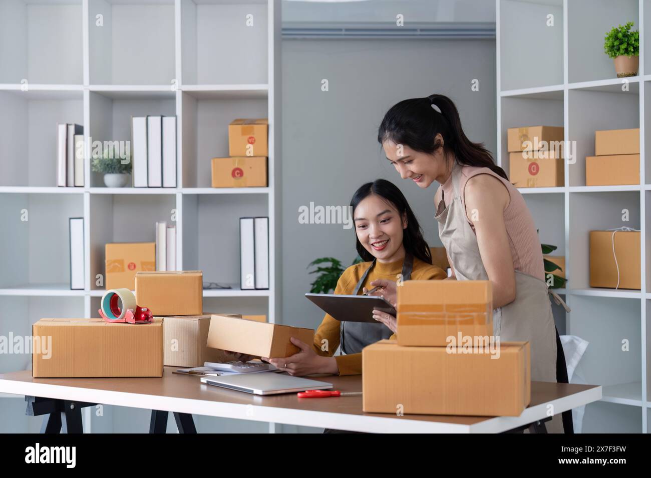 Asian women running a successful online business packaging orders and ...