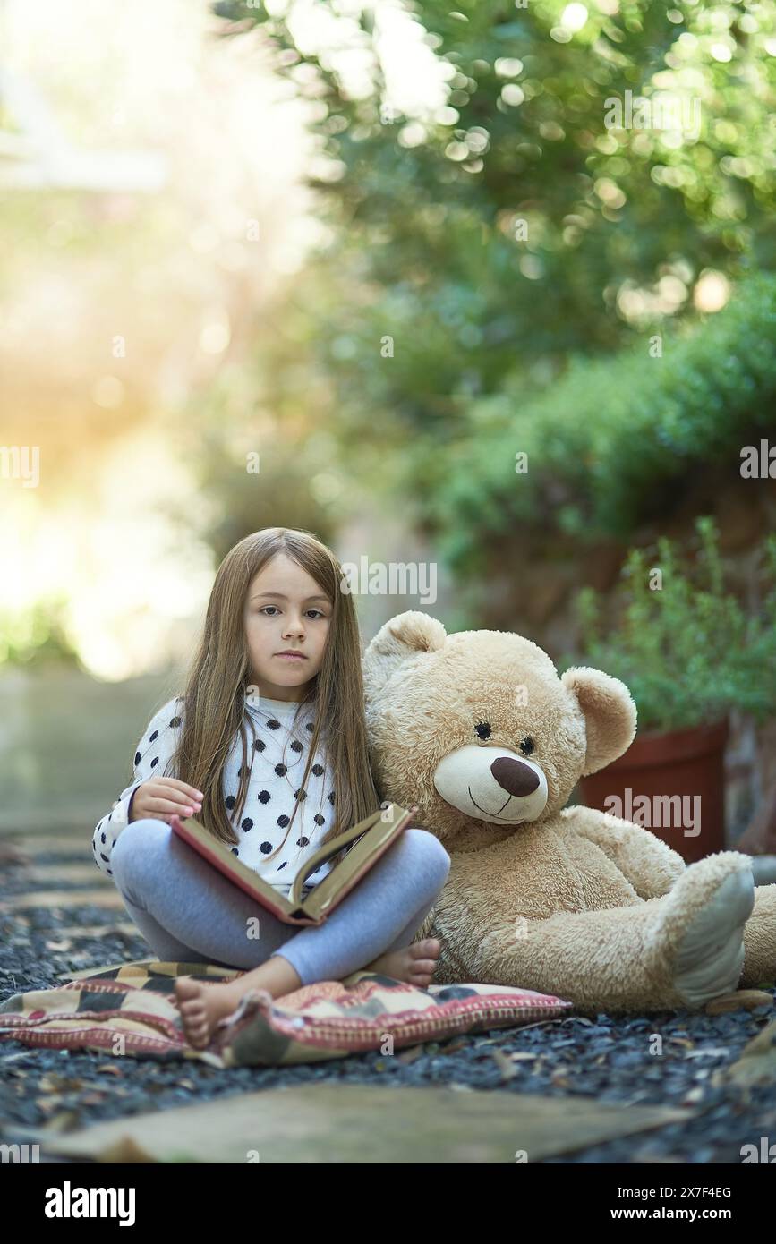 Backyard, relax and portrait of girl with teddy bear on ground for storytelling, learning and ...