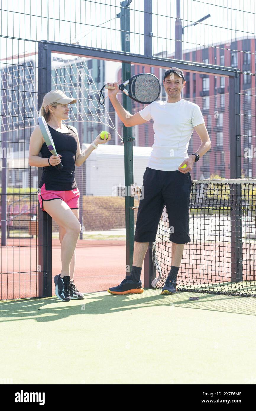Portrait of two smiling sportsman's posing on padel court outdoor with ...