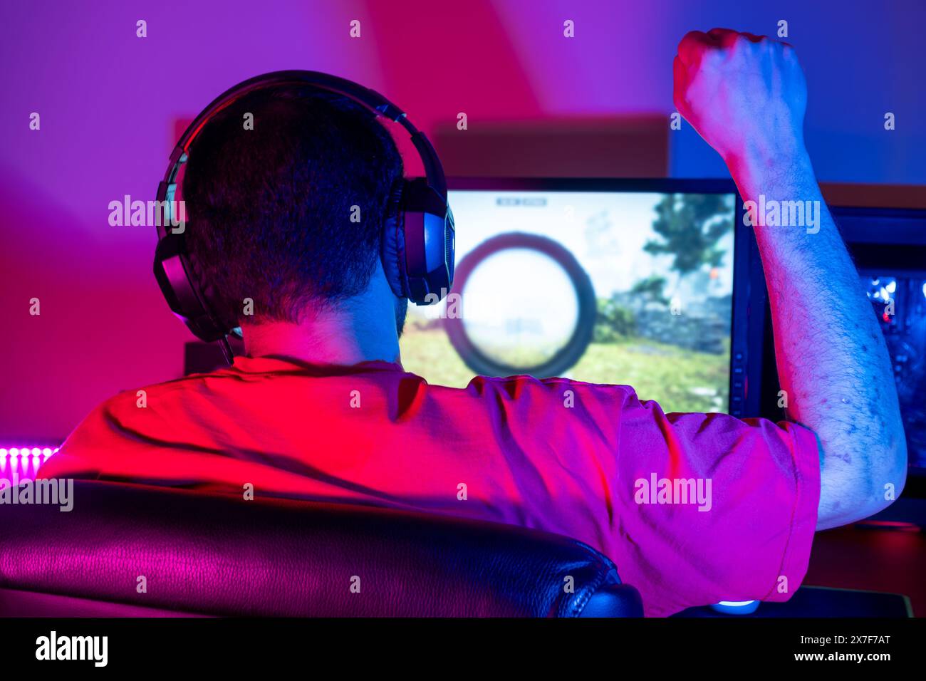 A gamer raising arms in victory, celebrating a successful game outcome ...