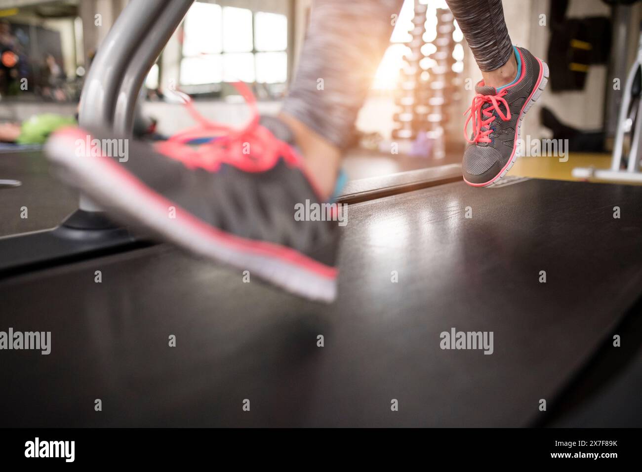 Closeup of feet in gym, running on treadmill. Routine workout for woman ...