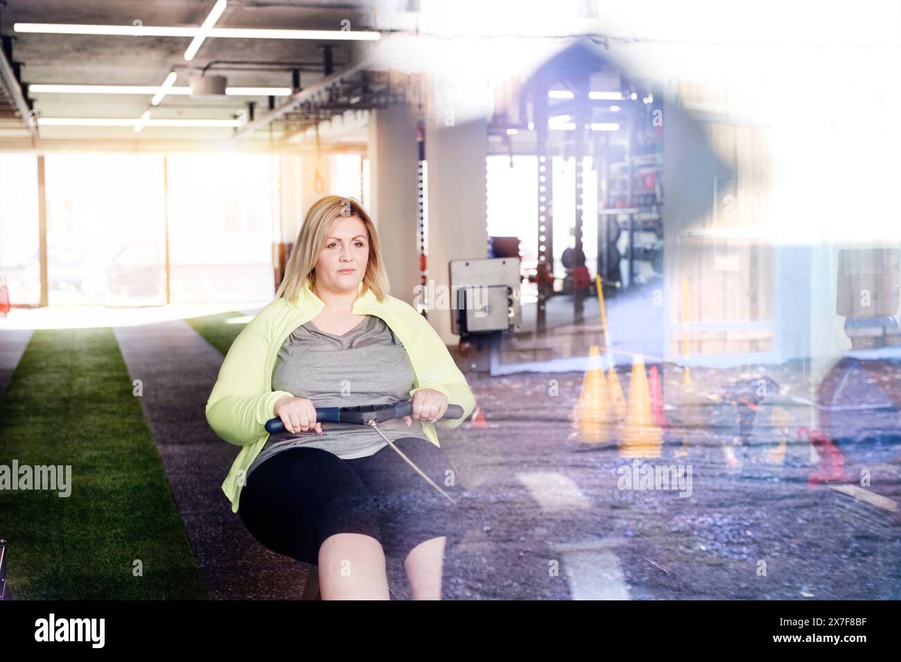 Overweight woman exercising on rowing machine. Routine workout for ...