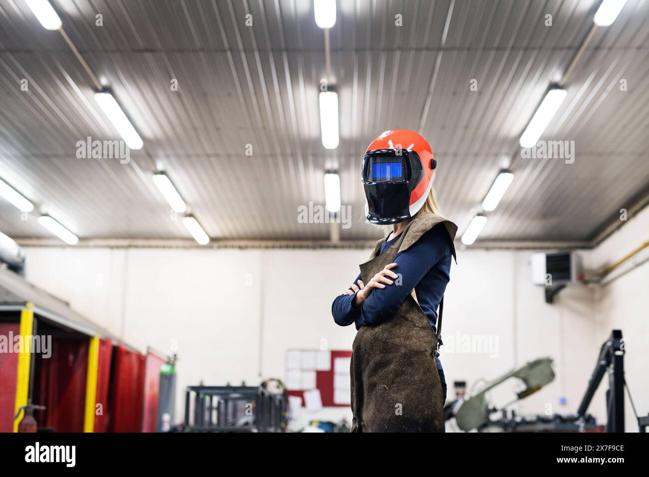 Beautiful blonde woman works as a welder in workshop, operating welding ...