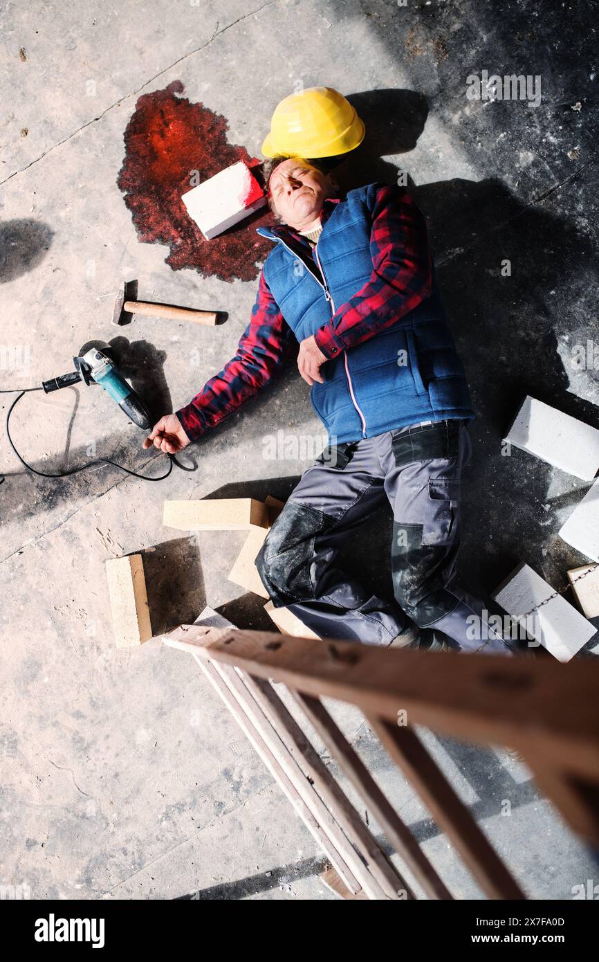 An unconscious man worker lying on the floor after a head injury. Work ...