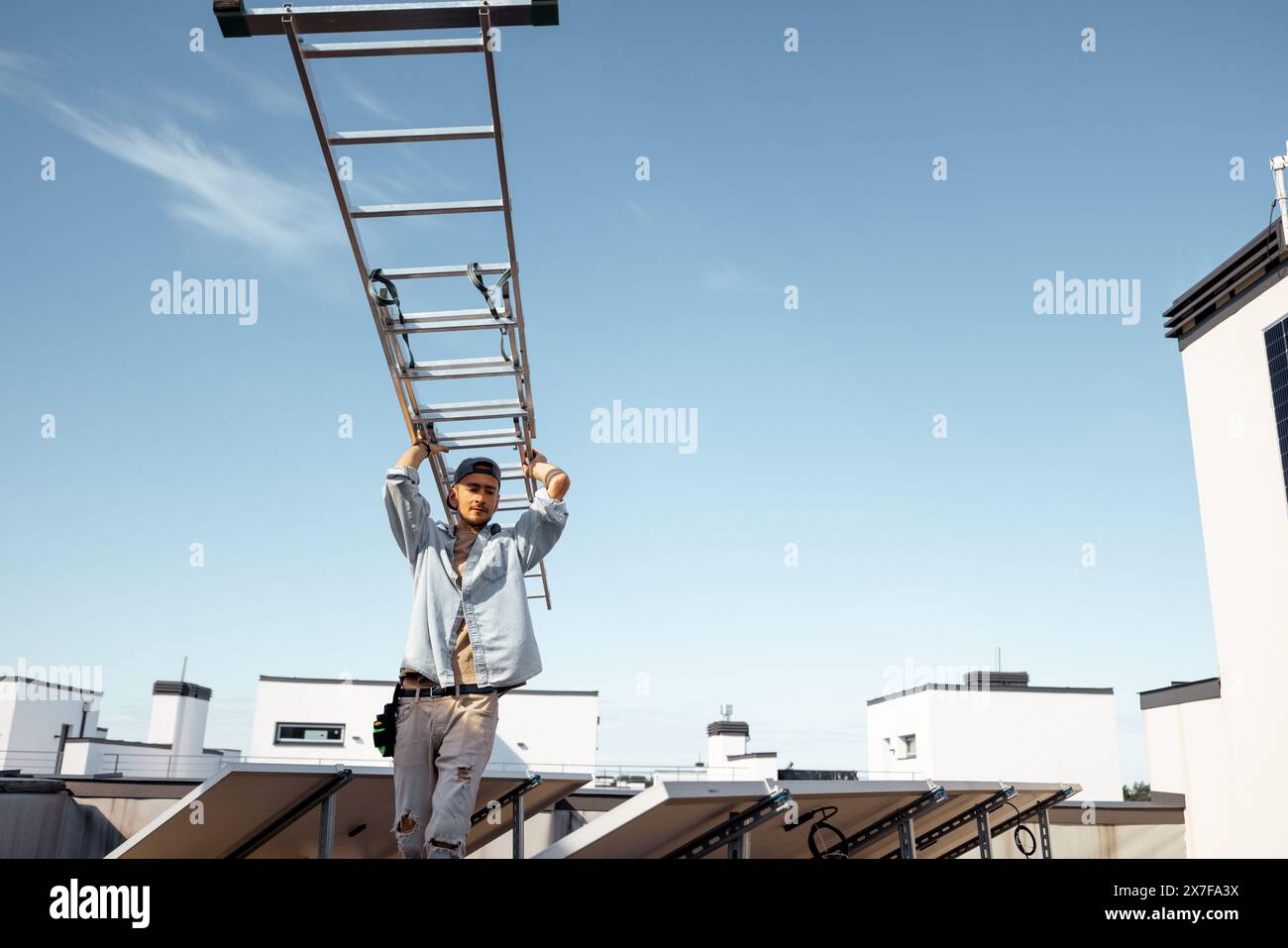 Man carries ladder during solar panels installation Stock Photo - Alamy