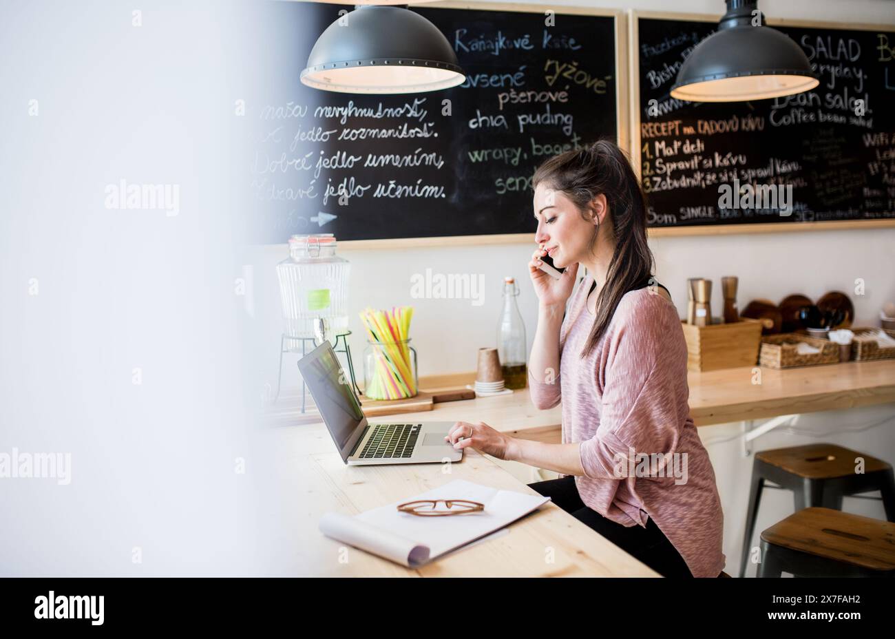 Beautiful woman making phone call in small local bistro. Female ...