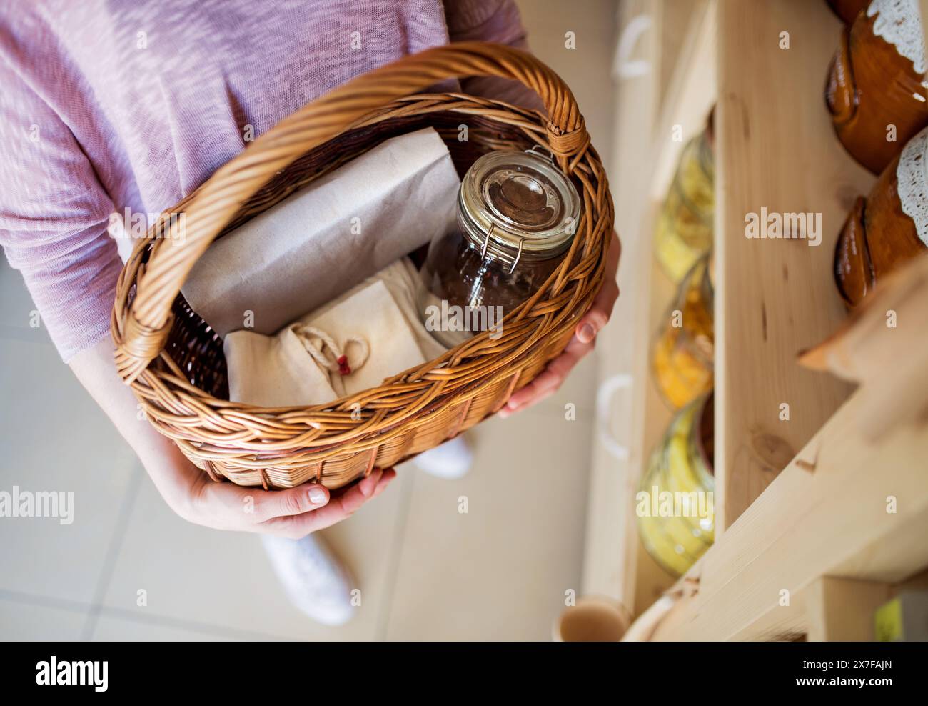 Female customer shopping in package-free store using reusable ...
