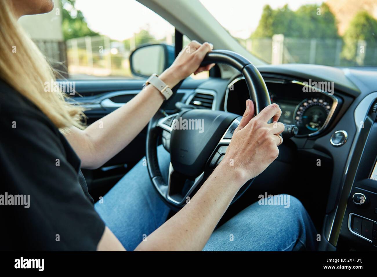 Woman driving car on country road at sunset. Female driver in vehicle ...