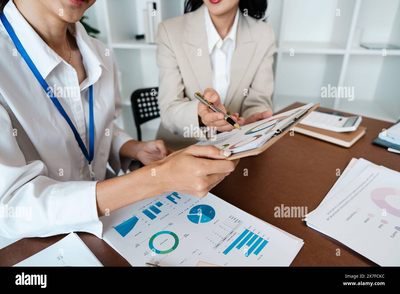 Collaborative business woman meeting hands analyzing financial charts ...