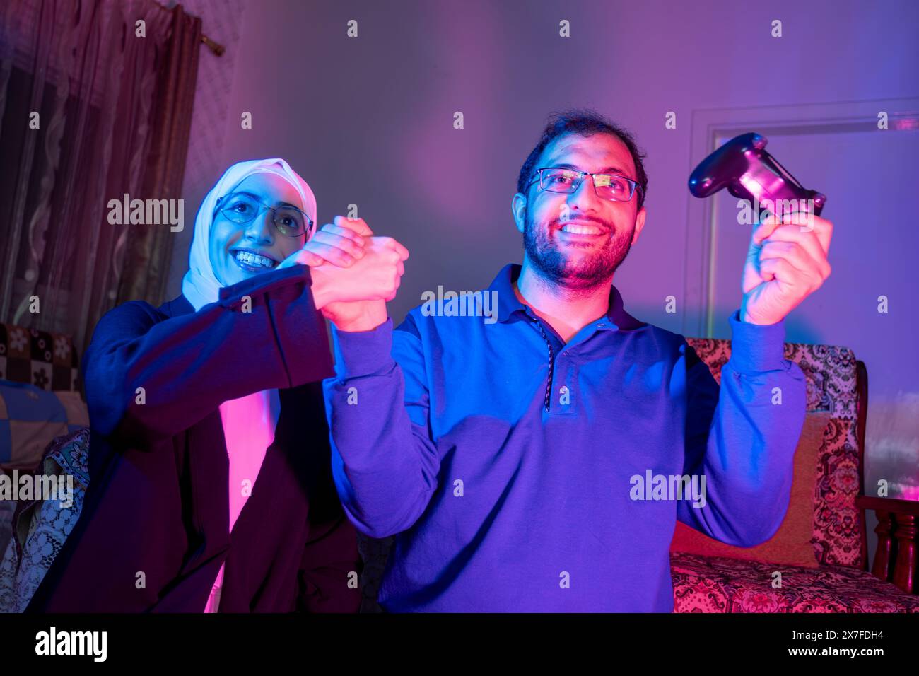 Couple or friends have shocking, exciting face with fun, using joystick ...