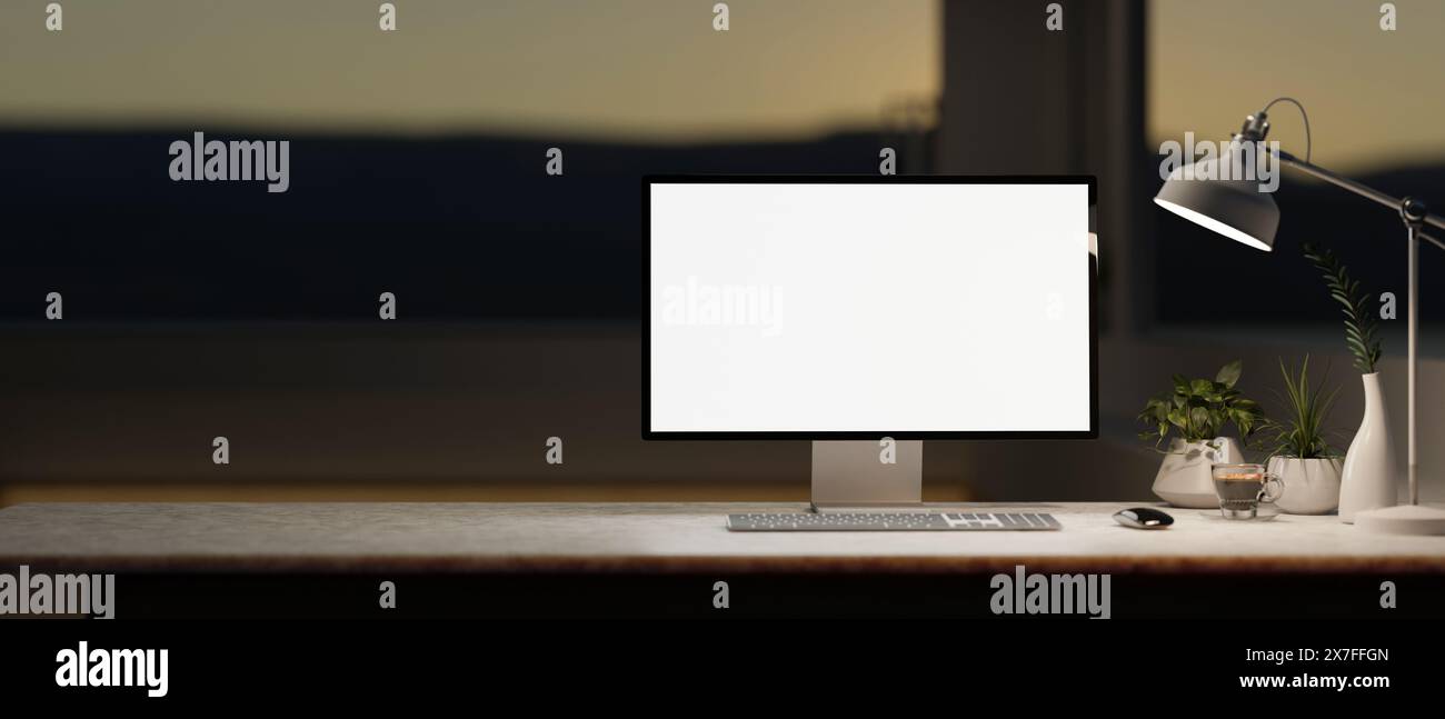 A computer desk in a modern, dark room in the evening features a white ...
