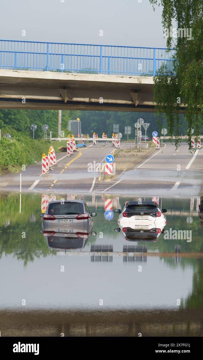 20 May 2024, Saarland, Saarbrücken: Two cars are standing under a Saar ...