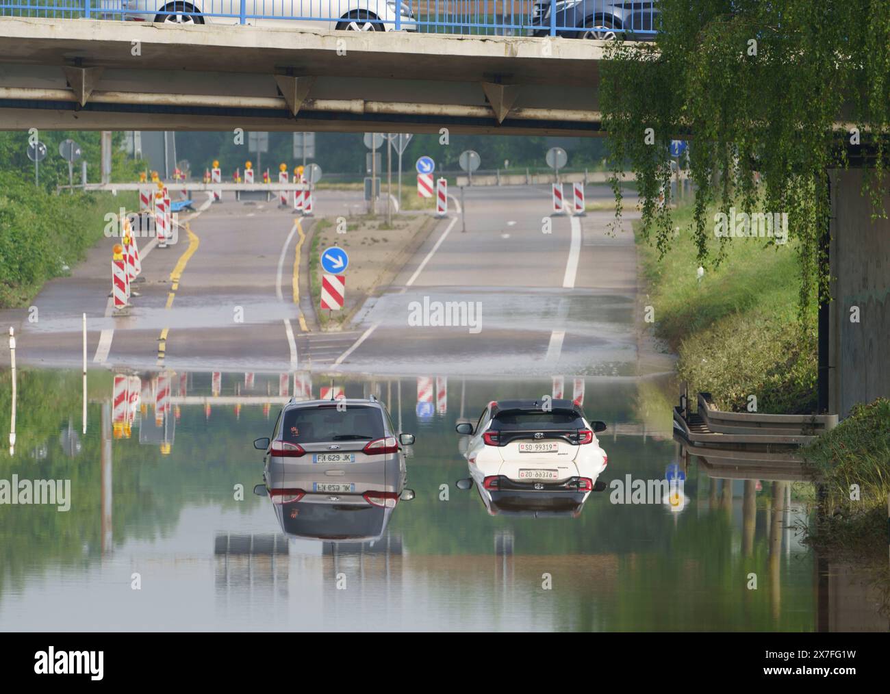 20 May 2024, Saarland, Saarbrücken: Two cars are standing under a Saar ...