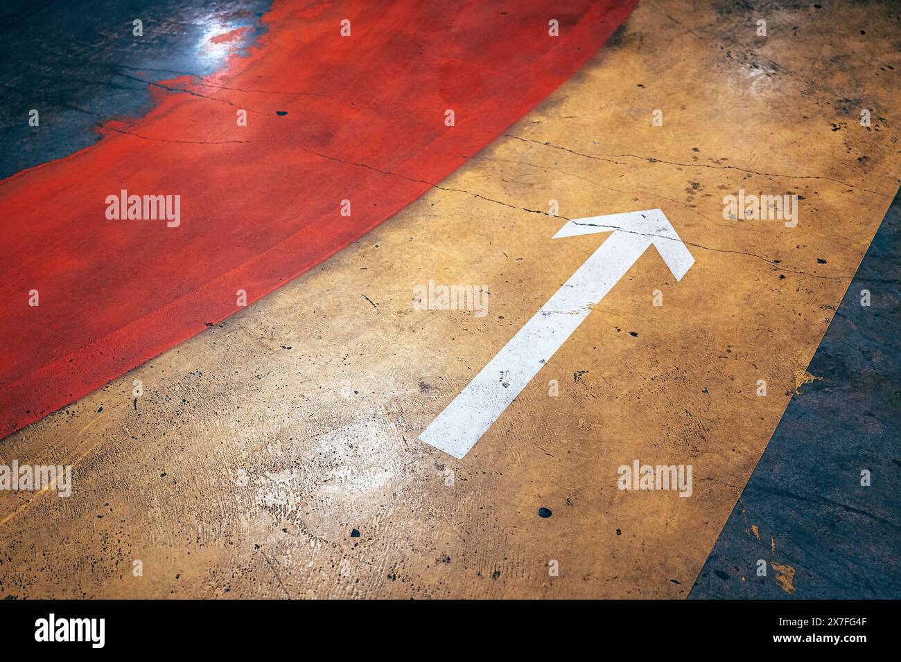 Direction arrow on pedestrian path in underground garage in colors og ...