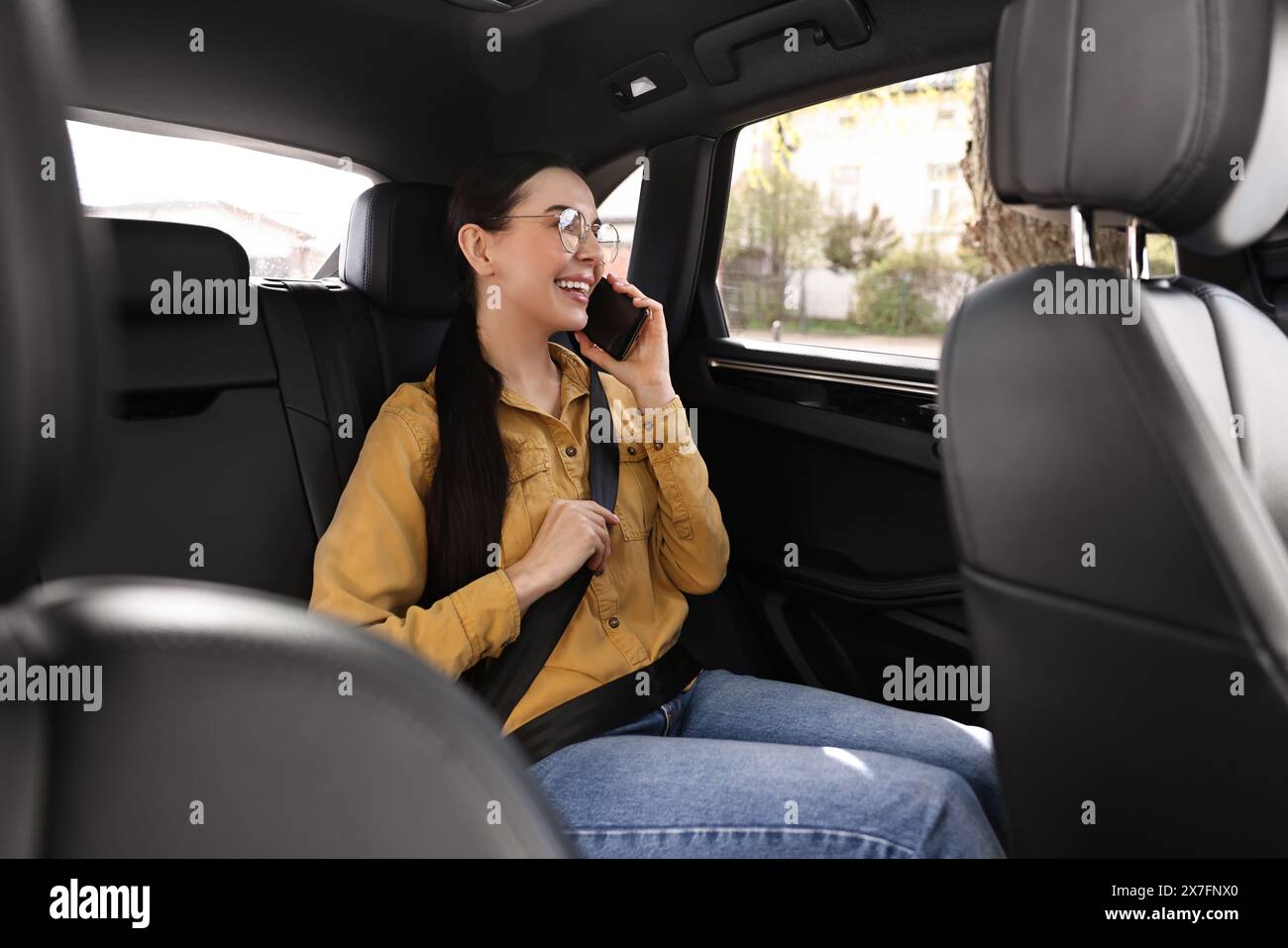 Woman with seatbelt talking on phone inside car Stock Photo - Alamy