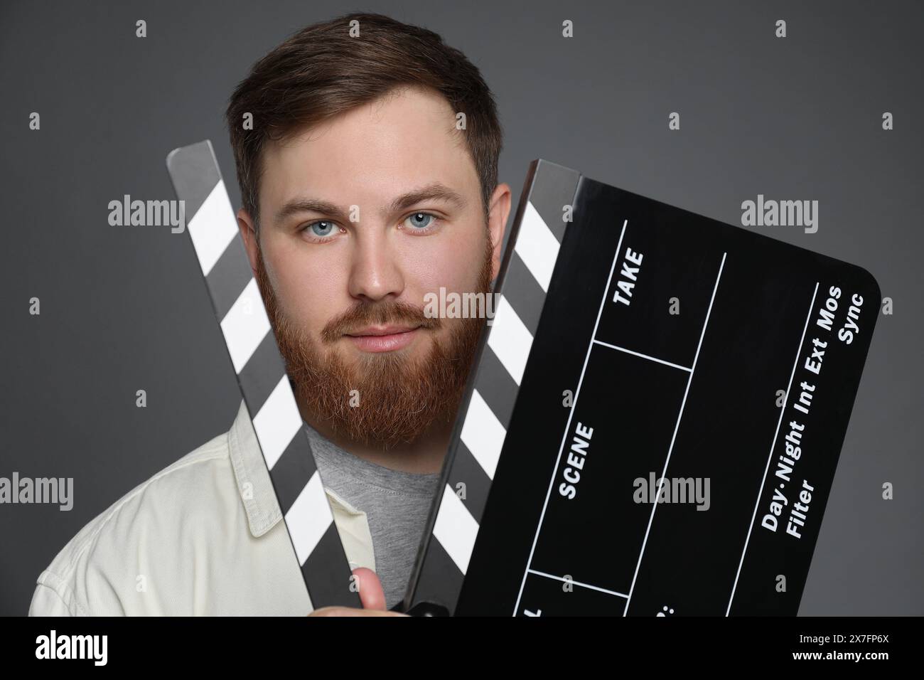 Making movie. Man with clapperboard on grey background Stock Photo - Alamy