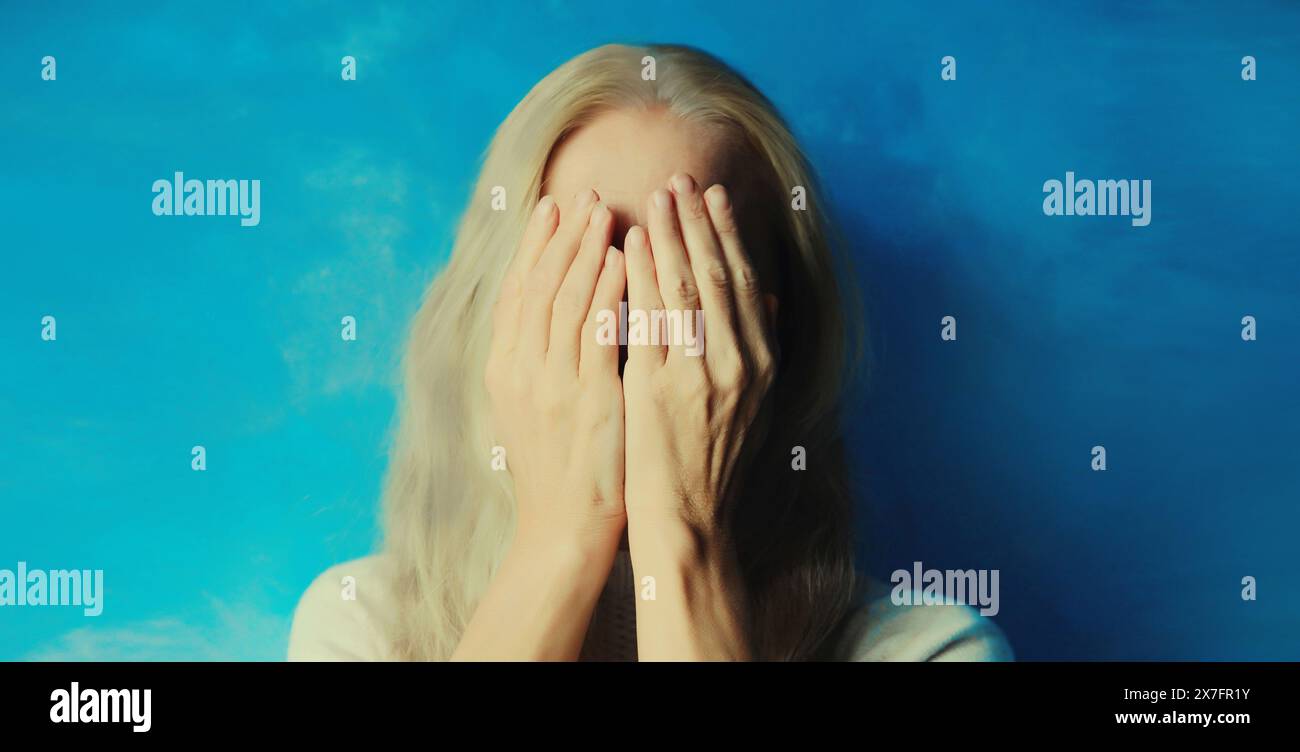 Upset sad crying woman covering her eyes and face with hands while ...