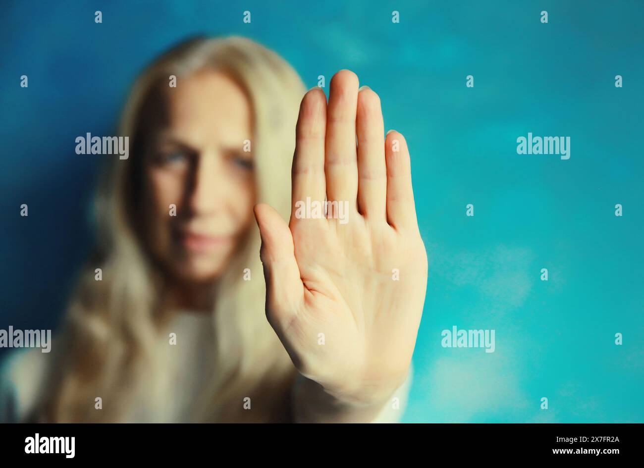 Upset young woman shows stop, no or enough sign with palm of hand ...