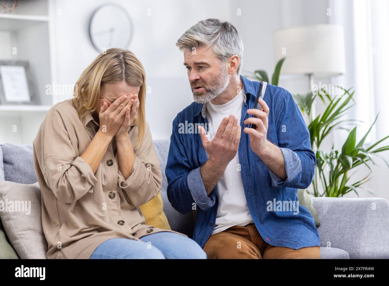 Middle-aged couple having an intense argument at home, with the woman ...