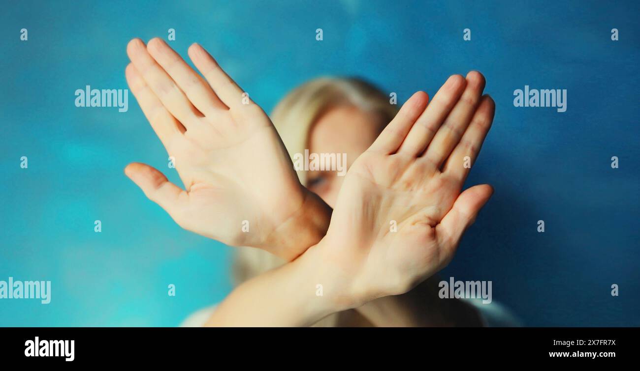 Upset young woman shows stop, no or enough sign with palm of hand ...