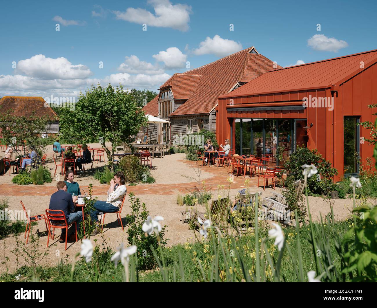 The outdoor cafe tables and visitors of Knepp Wilding Kitchen & Shop in ...