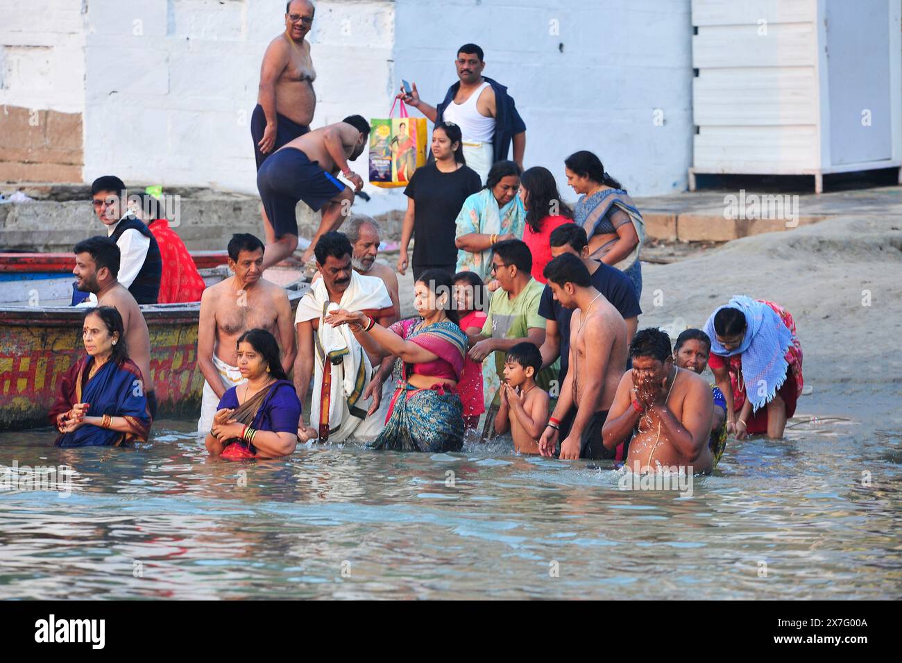 Hindu pilgrims bathing in the sacred river Ganges and pray, Varanasi ...