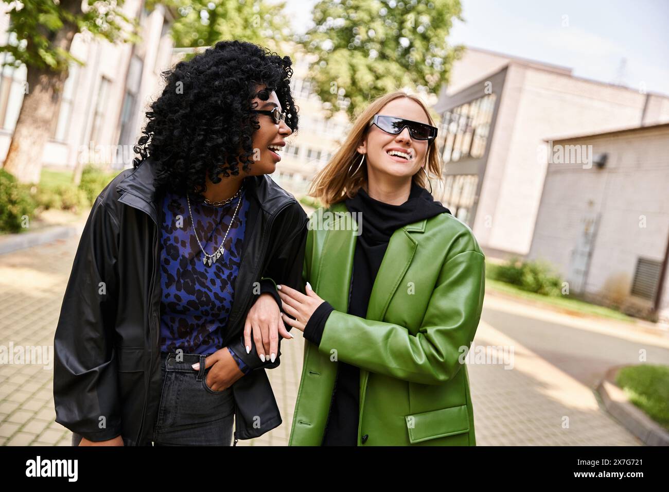 Two beautiful, diverse women stand together in cozy casual attire ...