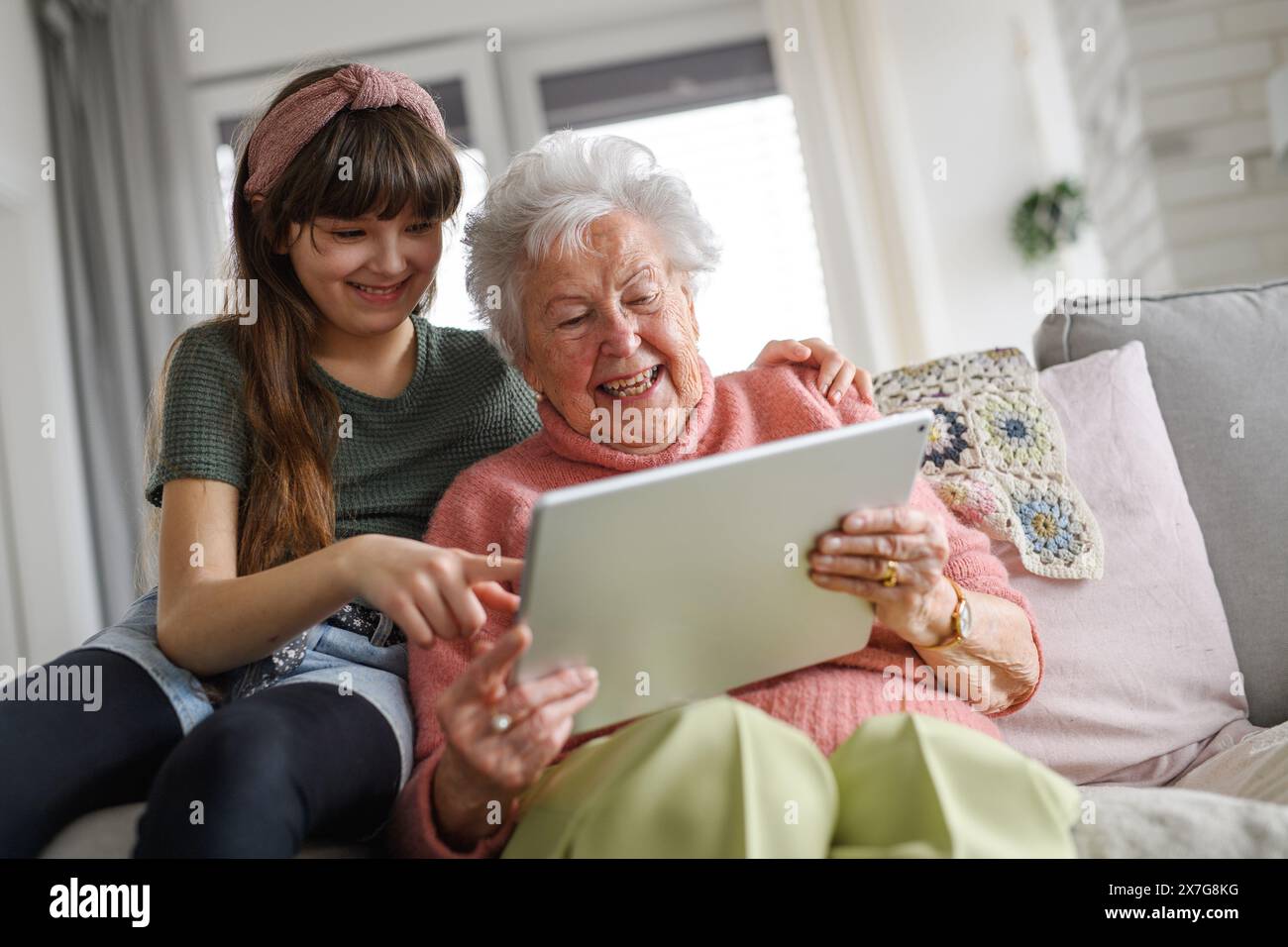 Grandmother with cute girl scrolling on tablet, girl teaching senior ...
