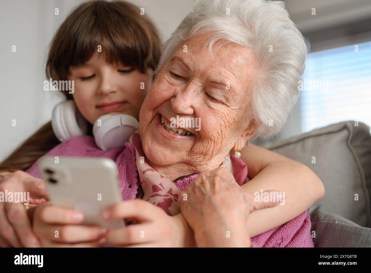 Grandmother with cute girl scrolling on smartphone, girl teaching ...