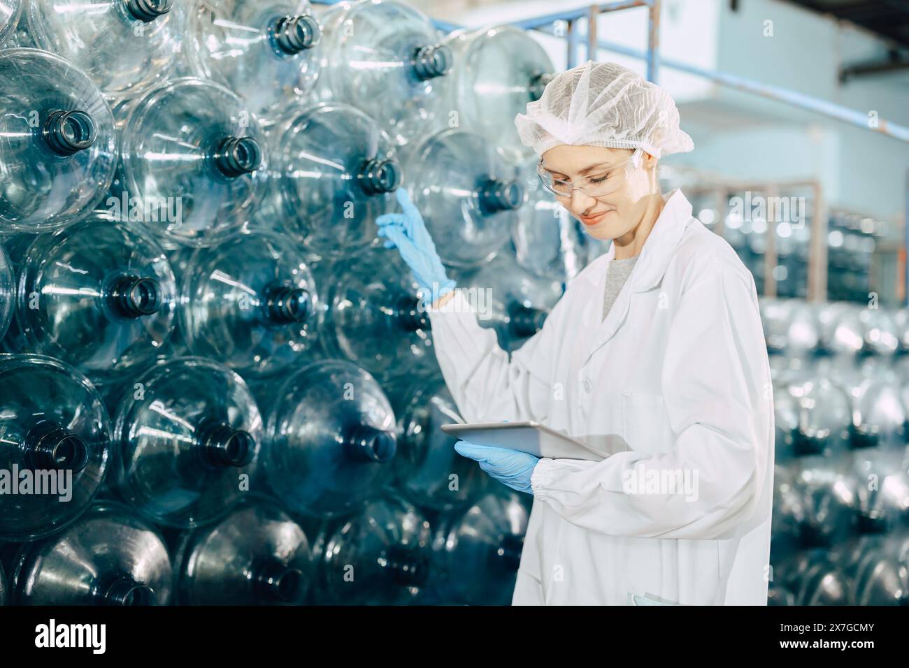 Senior women worker work in drink water factory counting check water ...