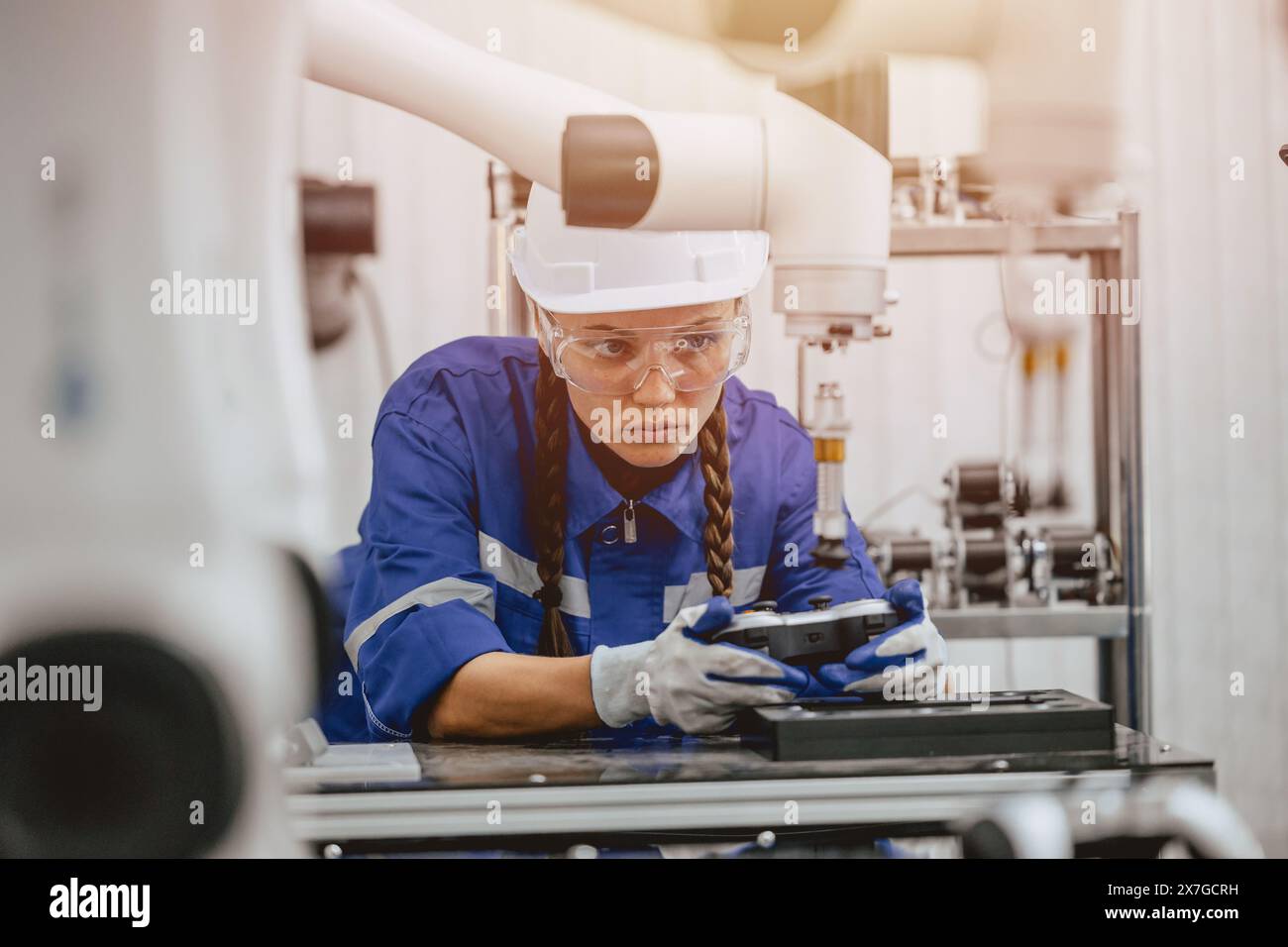 Engineer women university student learn to manual hand control operate industry robot arm with ...