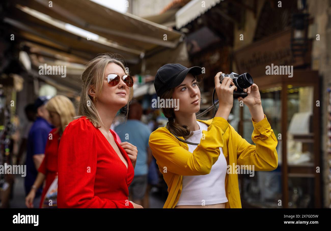 Two tourists take photos in a crowded tourist city Stock Photo - Alamy
