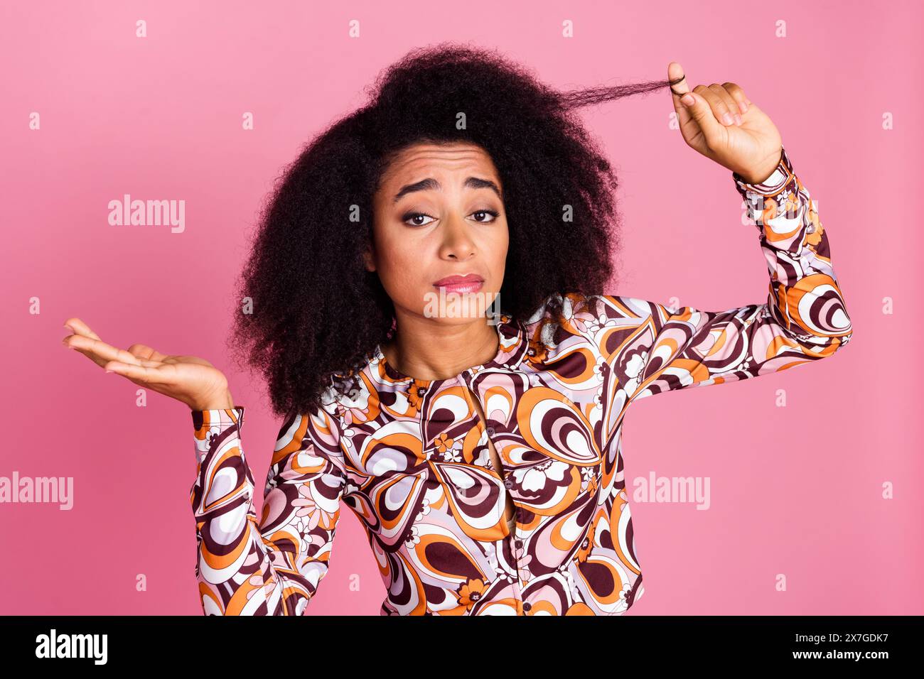 Photo of uncertain doubtful lady dressed print shirt holding hair curl ...