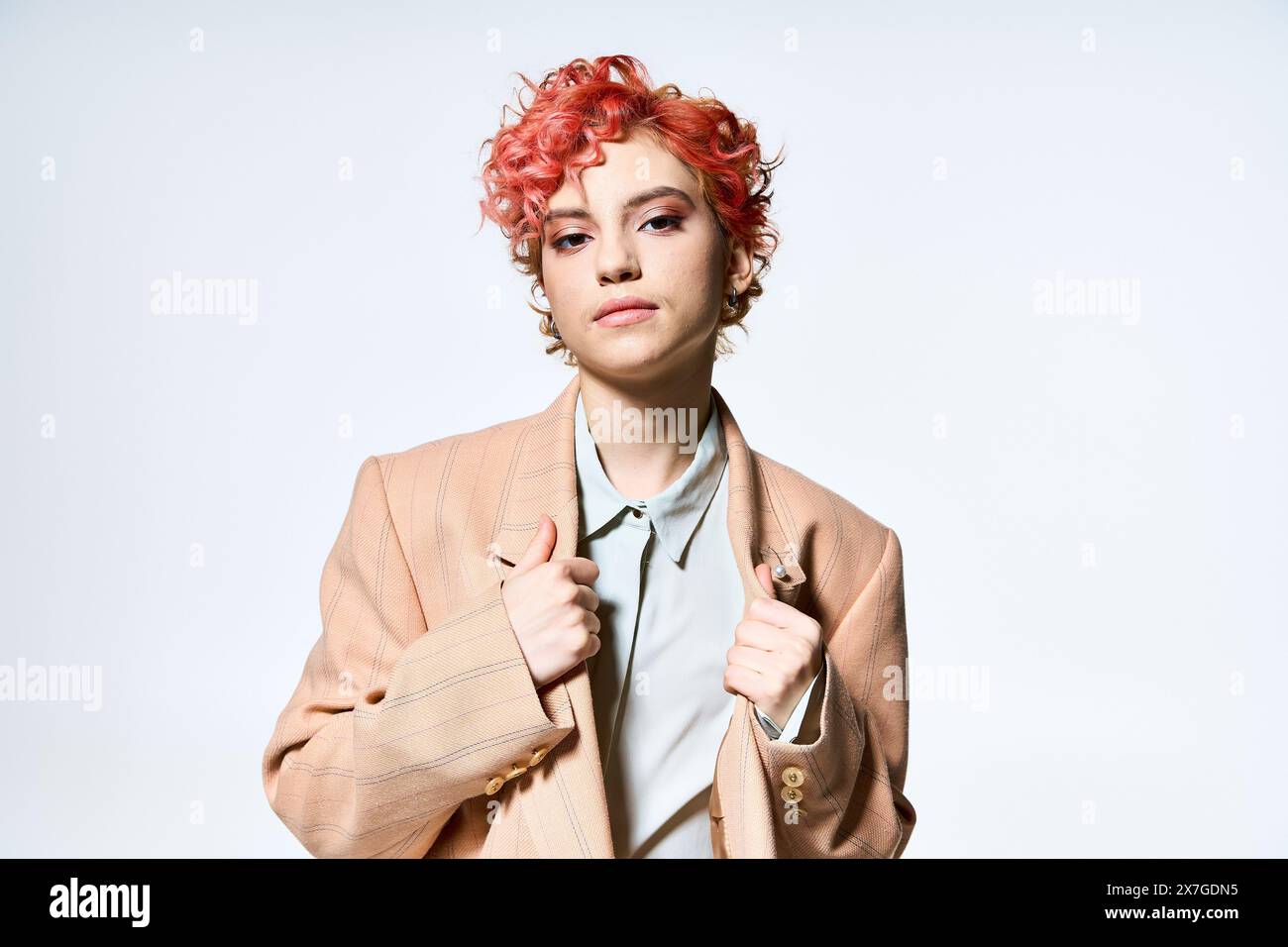 A striking woman with red hair strikes a pose in vibrant attire Stock ...